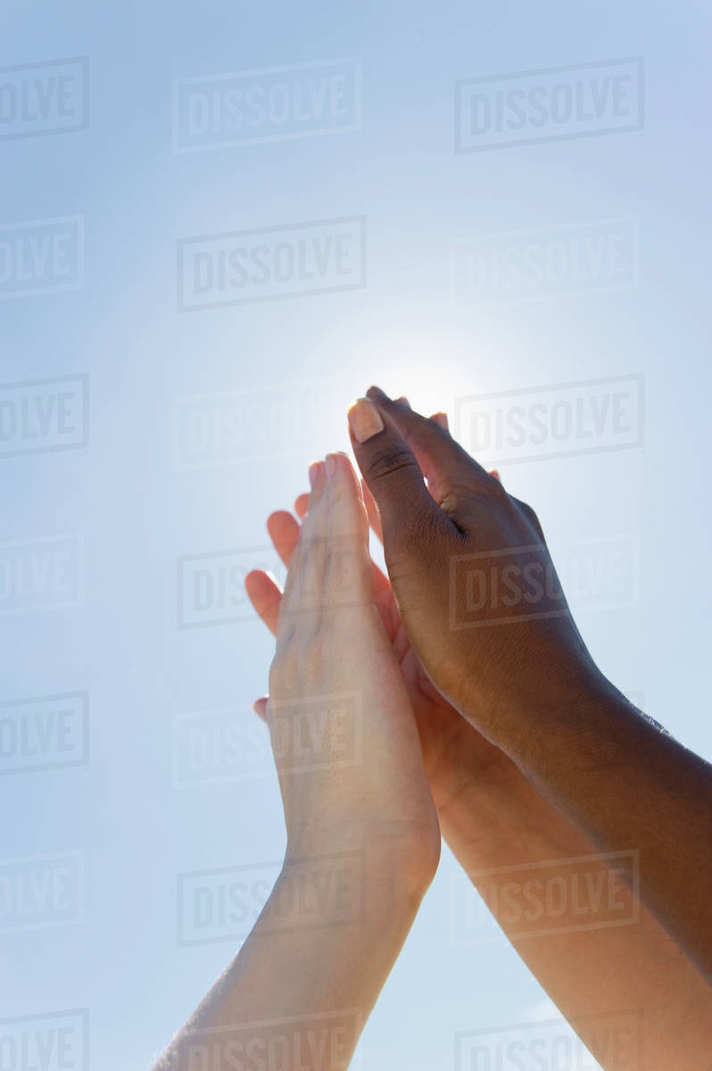 Hands held up in front of sunshine - Royalty-free Stock Photo | Dissolve