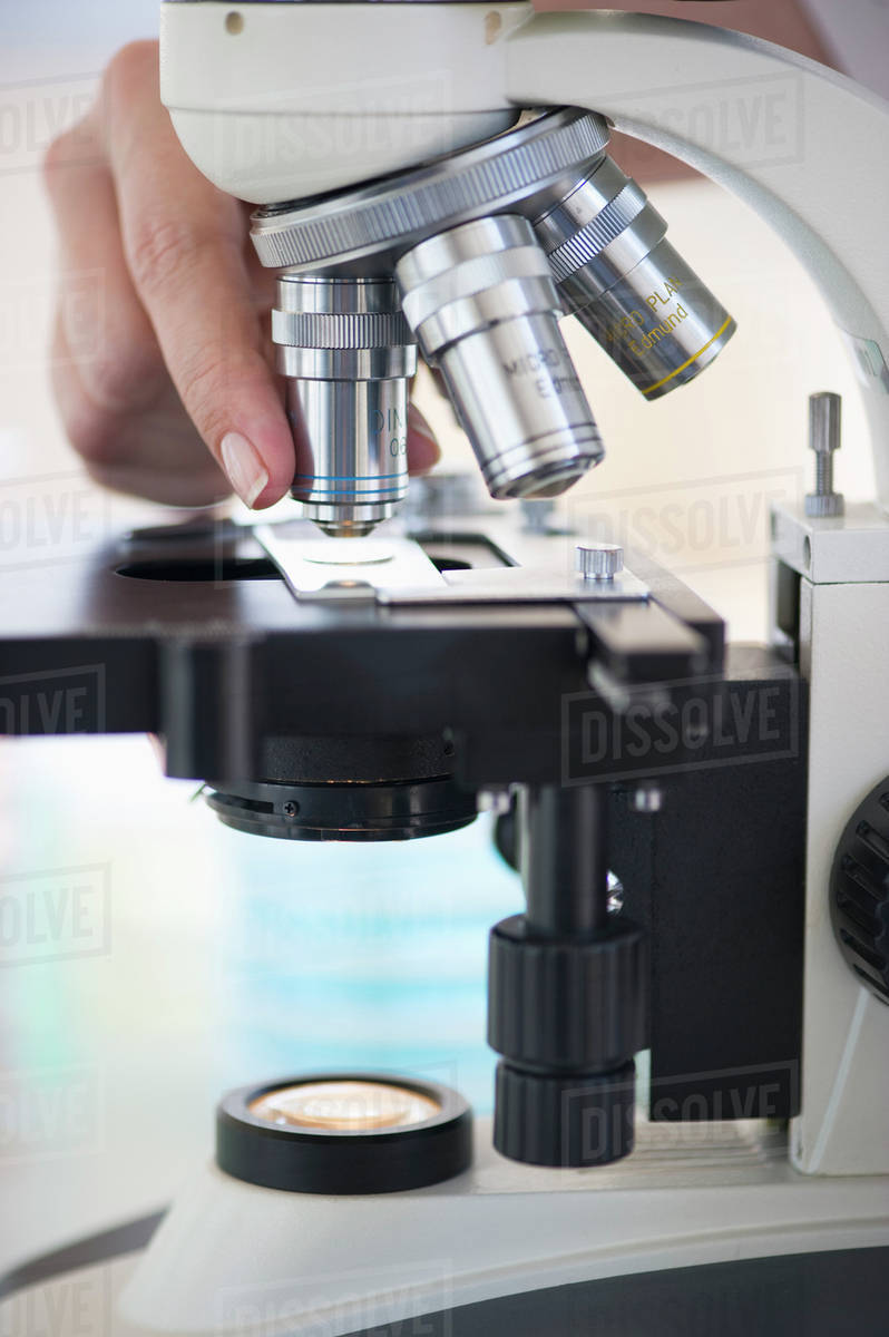 Hands on a microscope - Royalty-free Stock Photo | Dissolve