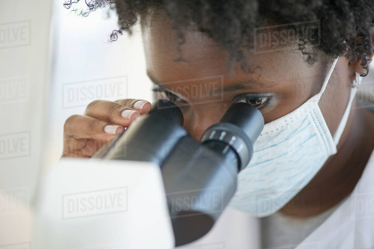 Researcher looking at specimen through microscope - Royalty-free Stock ...