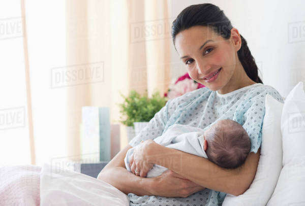 Mother holding newborn baby in hospital bed - Royalty-free Stock Photo ...