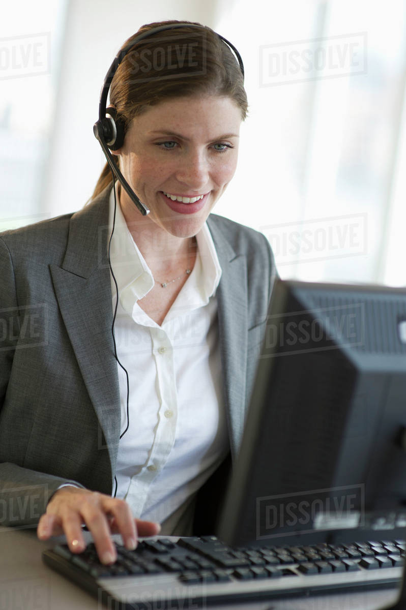Woman working with headset - Royalty-free Stock Photo | Dissolve