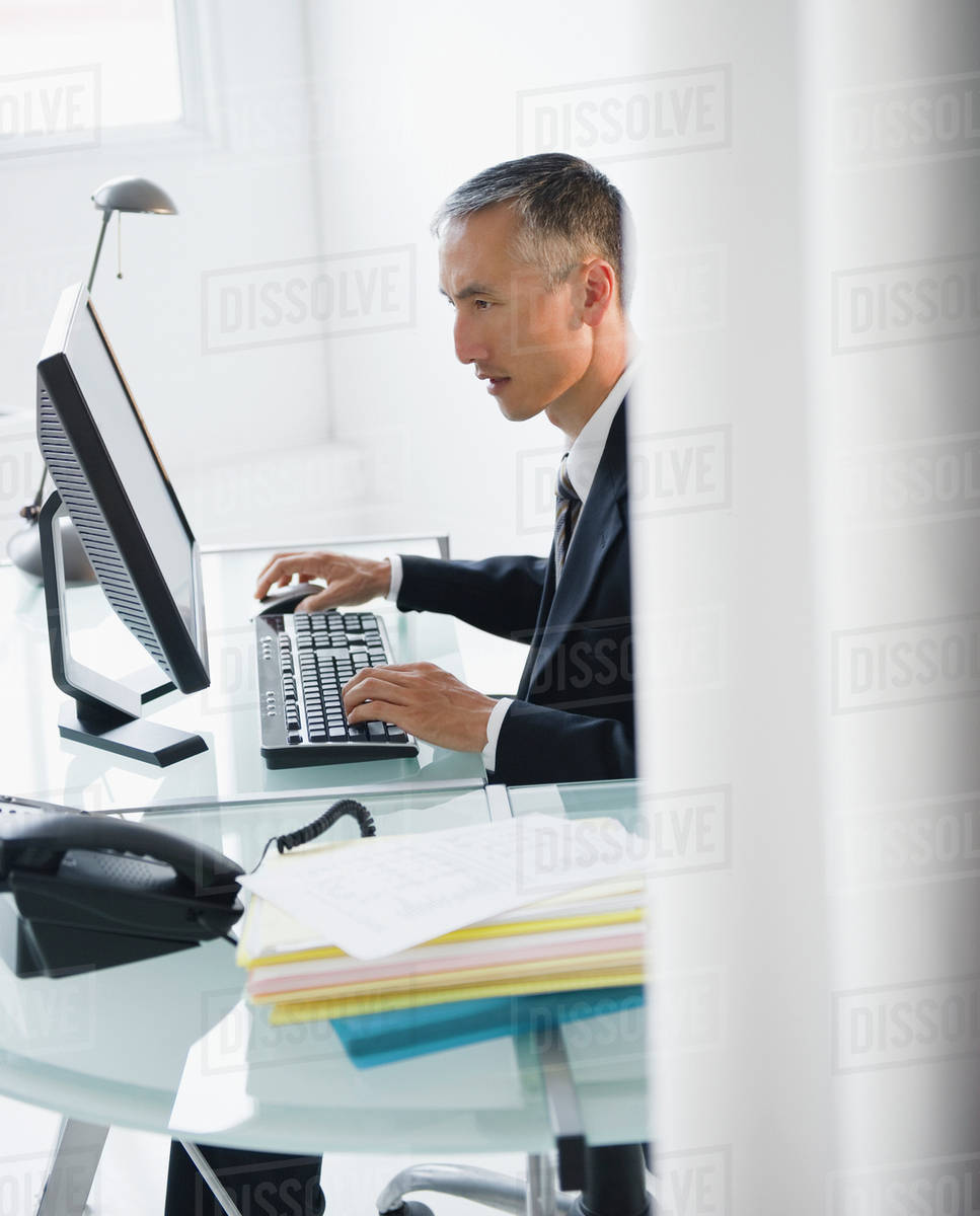 Businessman working on computer in office - Stock Photo - Dissolve