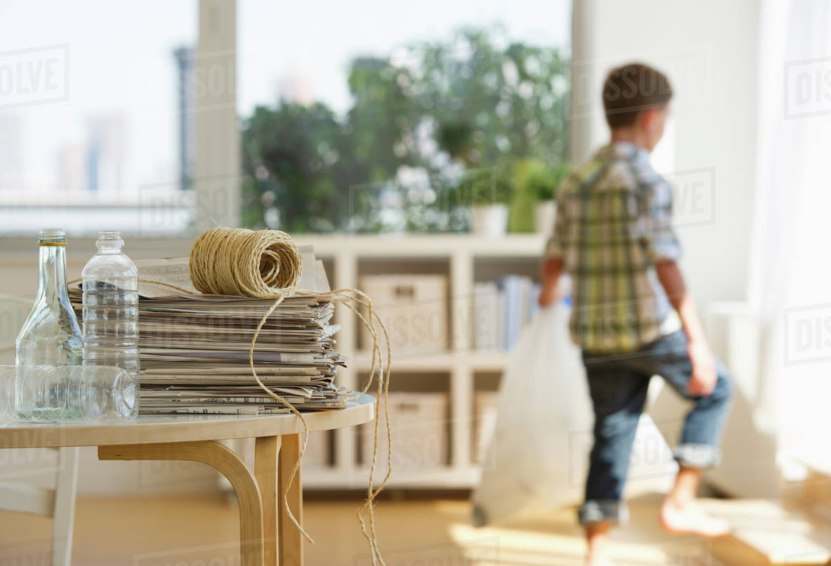 Boy (10-11) sorting garbage at home - Royalty-free Stock Photo | Dissolve