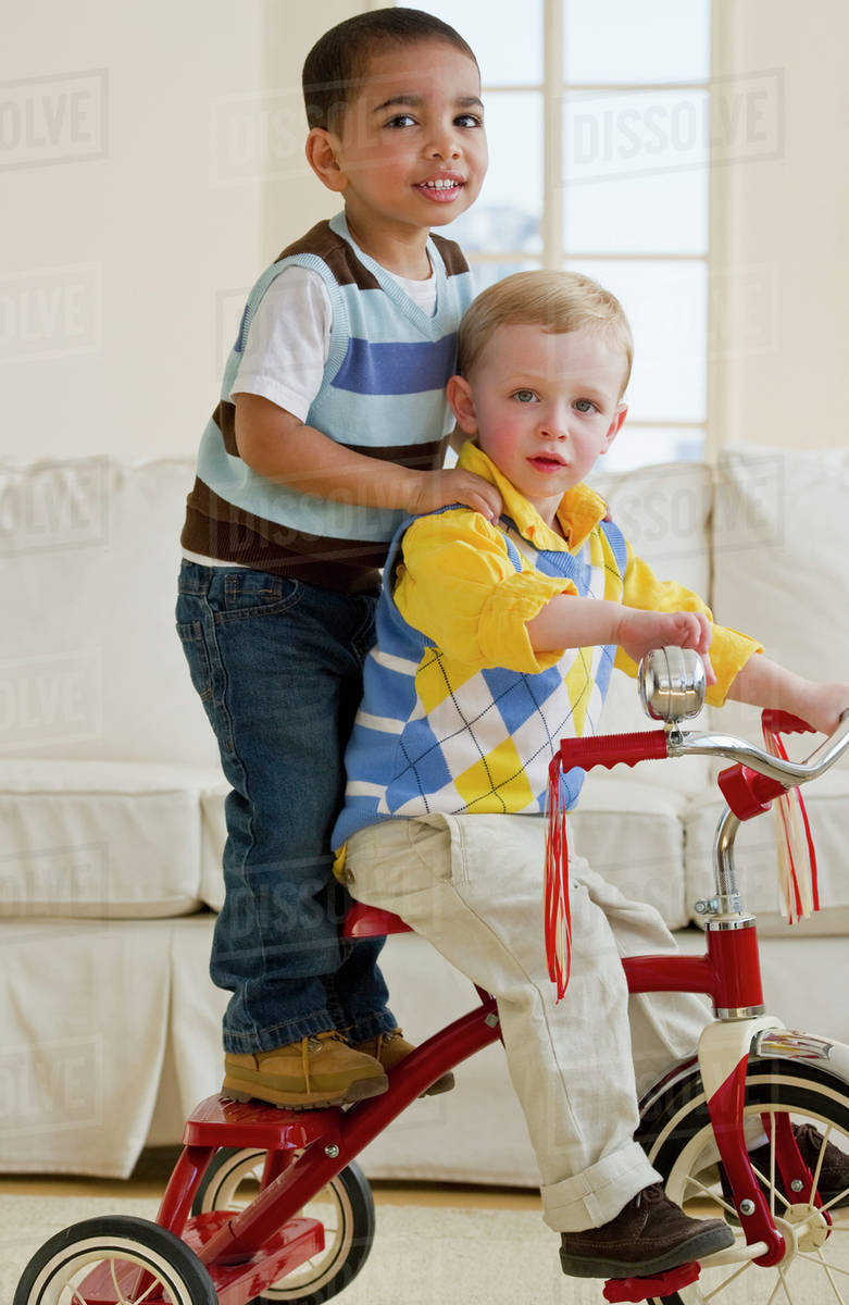 Two children on a tricycle - Royalty-free Stock Photo | Dissolve