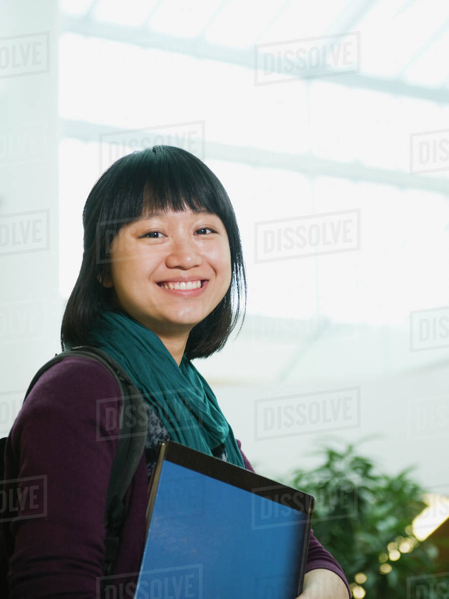 College student holding books - Royalty-free Stock Photo | Dissolve