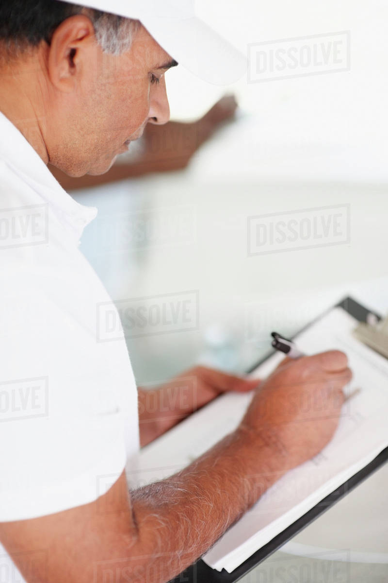 Repair person writing on clipboard - Royalty-free Stock Photo | Dissolve