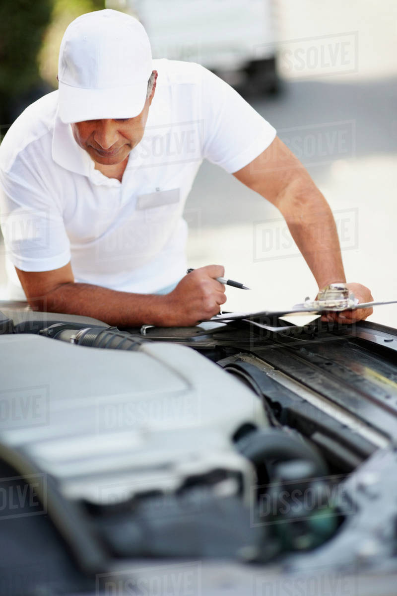 Man looking at car's engine - Royalty-free Stock Photo | Dissolve