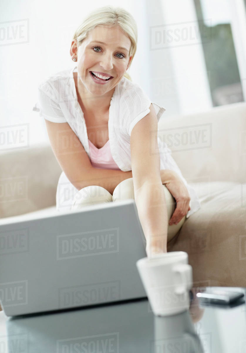 Pretty blond woman browsing the internet - Stock Photo - Dissolve