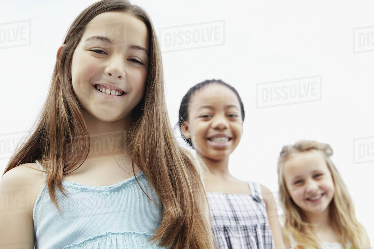 Three girls standing in a row - Royalty-free Stock Photo | Dissolve
