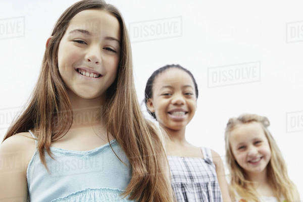 Three girls standing in a row - Royalty-free Stock Photo | Dissolve