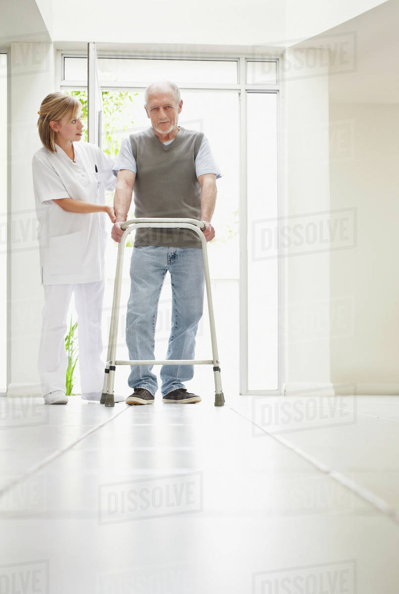 Nurse assisting patient in corridor of clinic - Royalty-free Stock ...