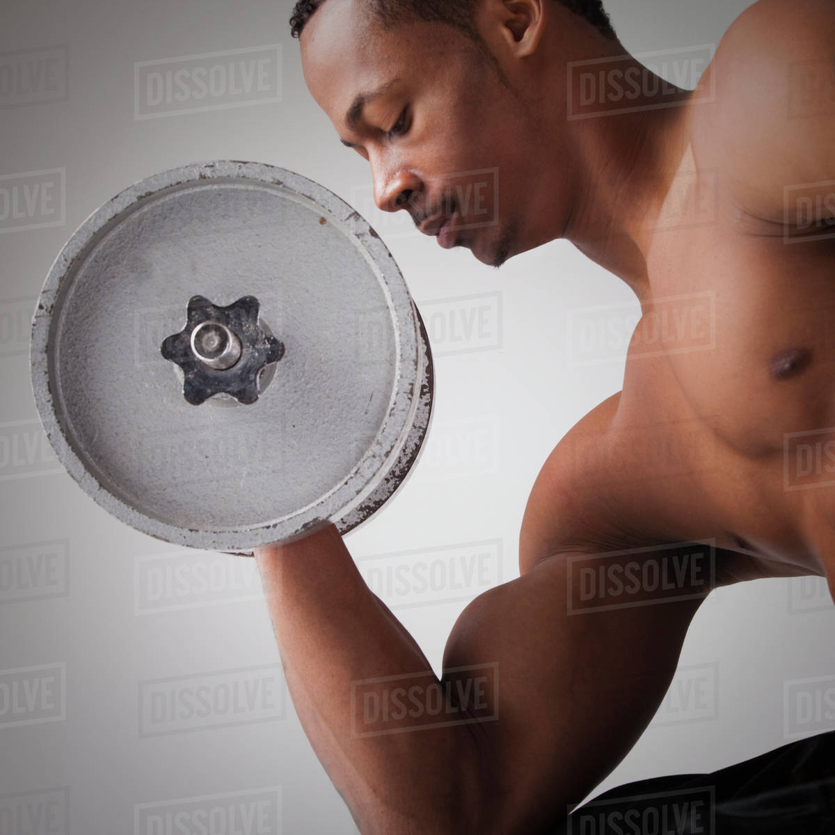 Muscular man lifting a dumbbell - Royalty-free Stock Photo | Dissolve