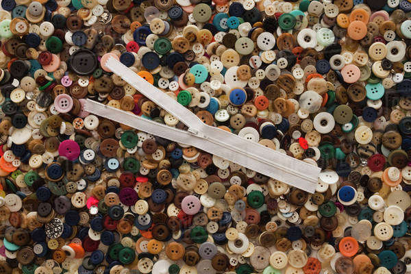 Zipper on top of a pile of buttons - Royalty-free Stock Photo | Dissolve