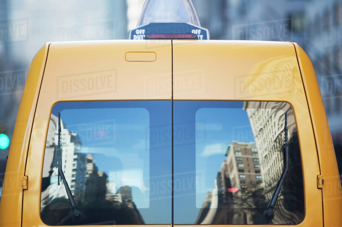 Reflection in rear window of yellow taxi - Stock Photo - Dissolve