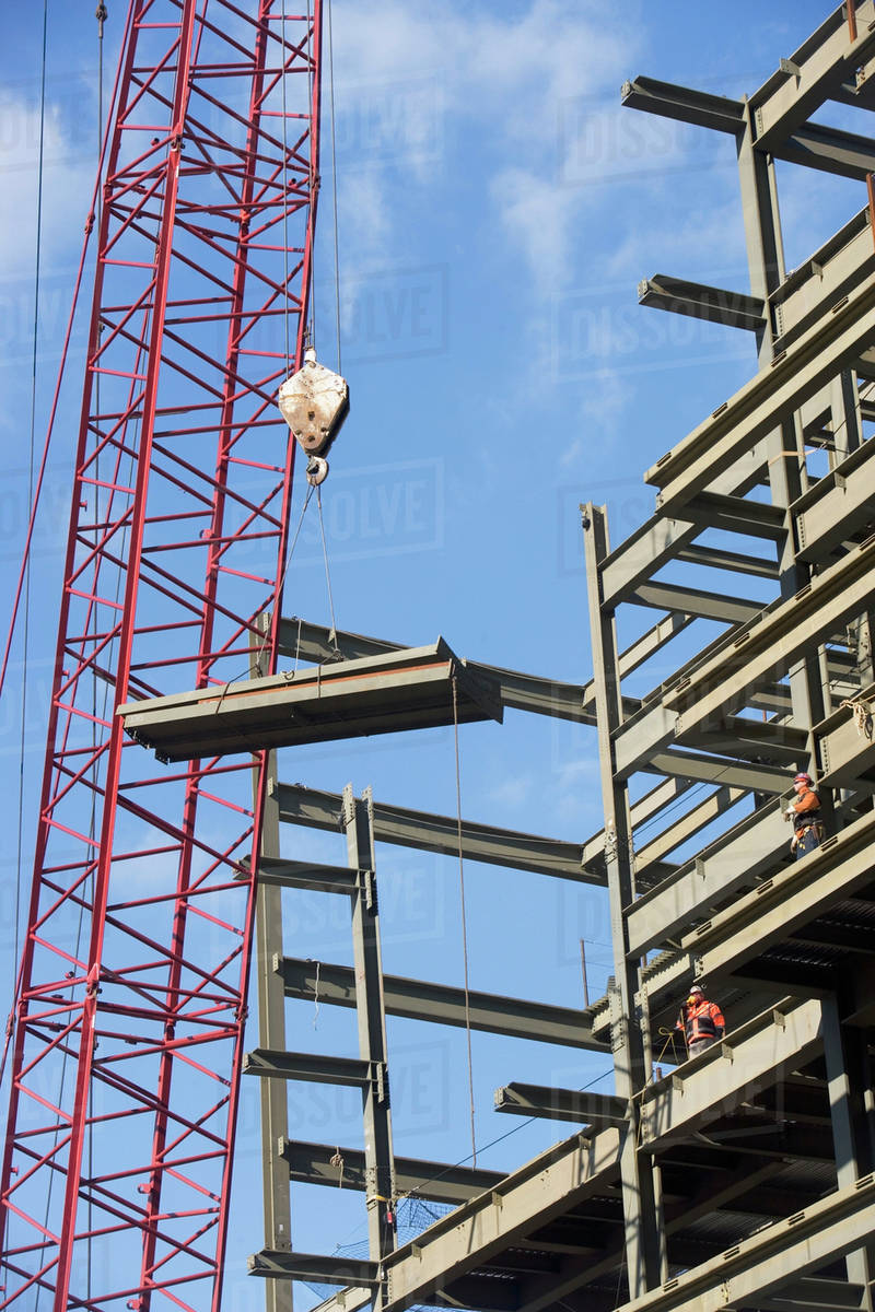 Crane lifting parts of metal frame - Royalty-free Stock Photo | Dissolve