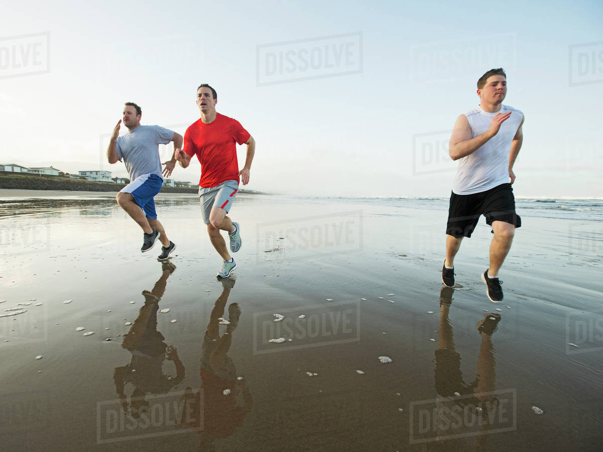 Men running on beach - Stock Photo - Dissolve
