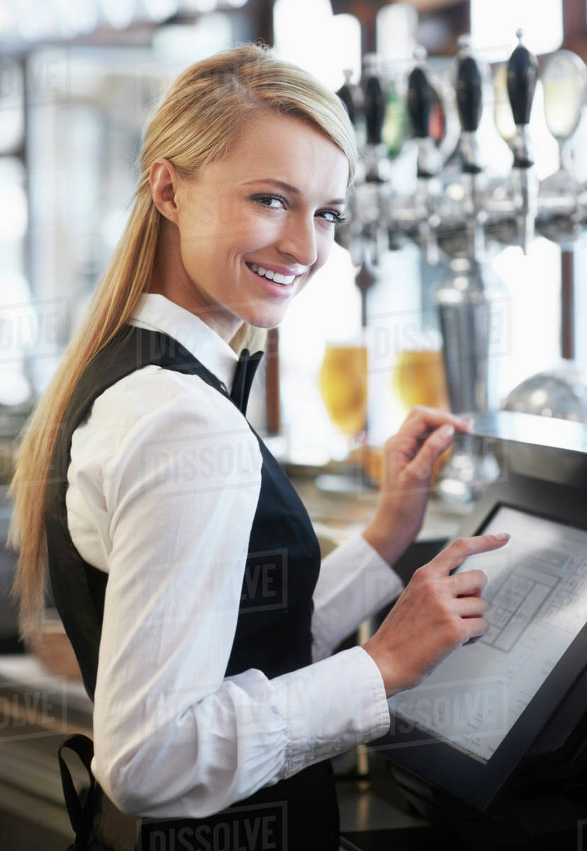 Young waitress using computer at restaurant counter - Royalty-free ...