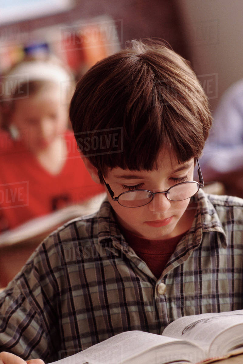 Elementary school student reading at his desk - Royalty-free Stock ...