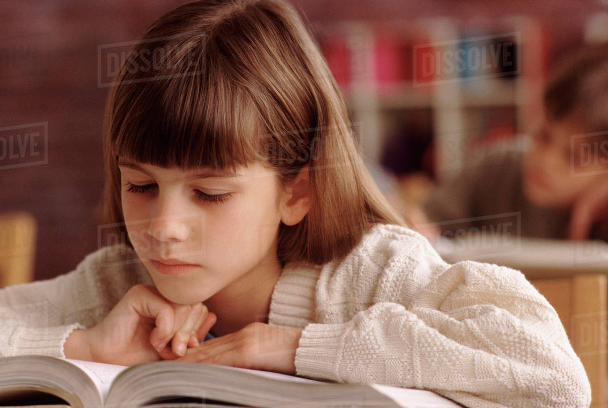 Elementary school student reading book at her desk - Royalty-free Stock ...