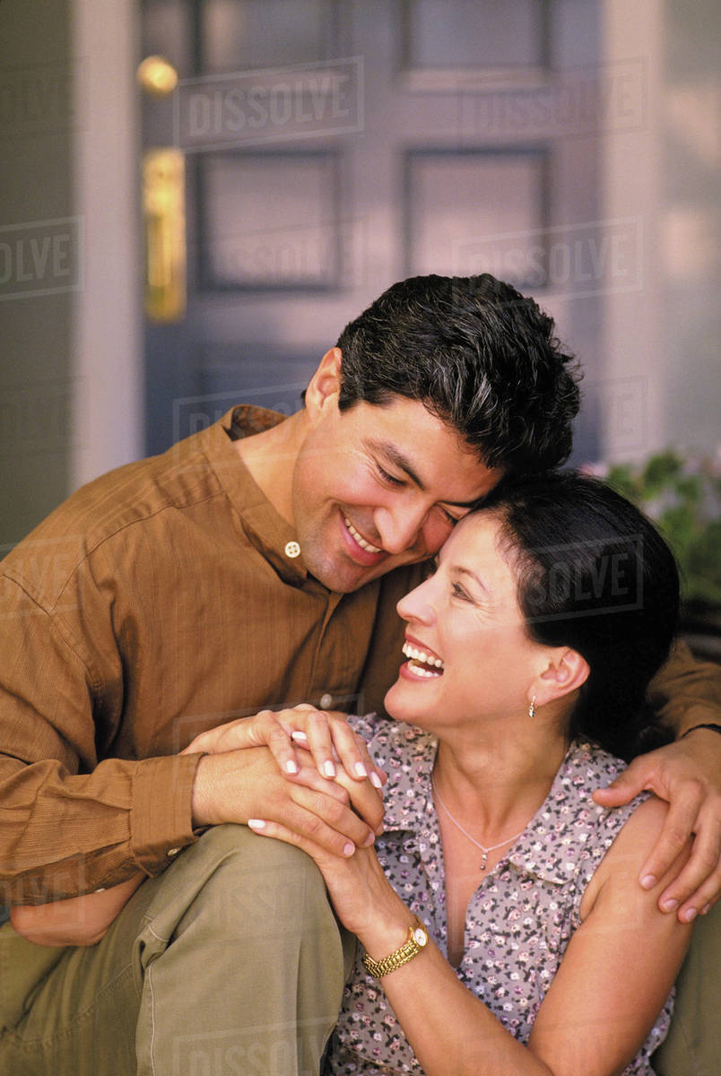 Happy couple sitting in front of their home - Royalty-free Stock Photo ...