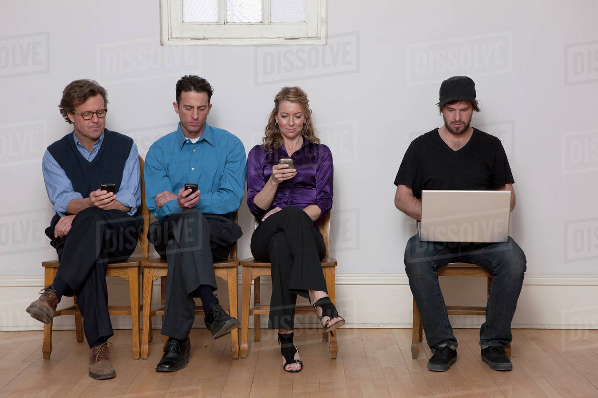 Four people sitting in a row - Royalty-free Stock Photo | Dissolve