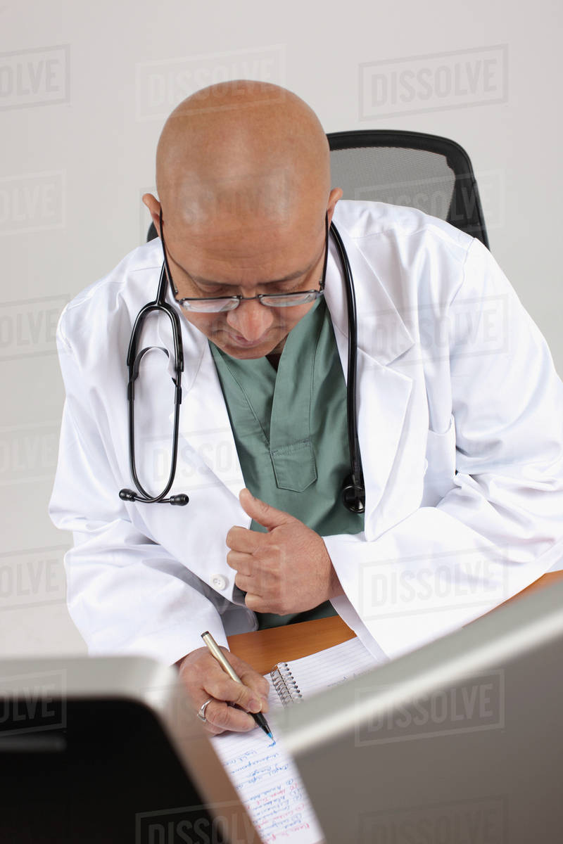 Doctor working at his desk - Royalty-free Stock Photo | Dissolve