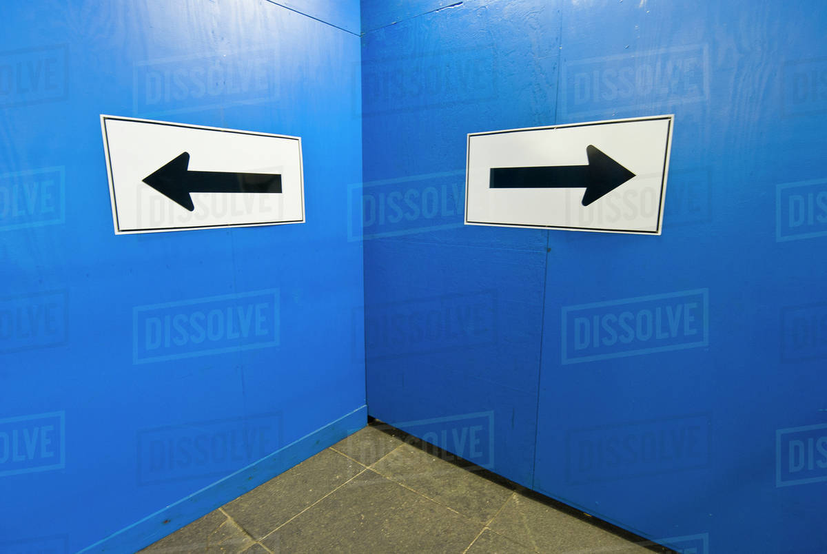 Arrow signs on blue wall - Stock Photo - Dissolve