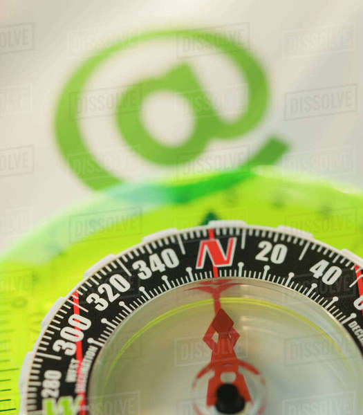 Close up of compass and “at” symbol - Royalty-free Stock Photo | Dissolve