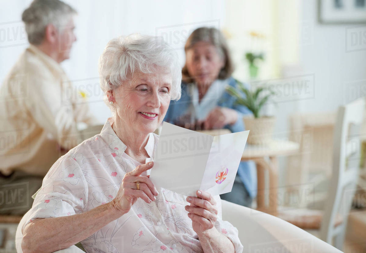 Senior woman reading greeting card - Royalty-free Stock Photo | Dissolve