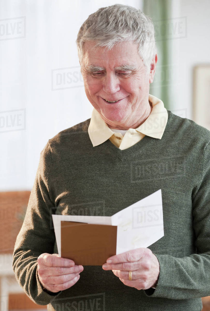 Senior man reading greeting card - Royalty-free Stock Photo | Dissolve