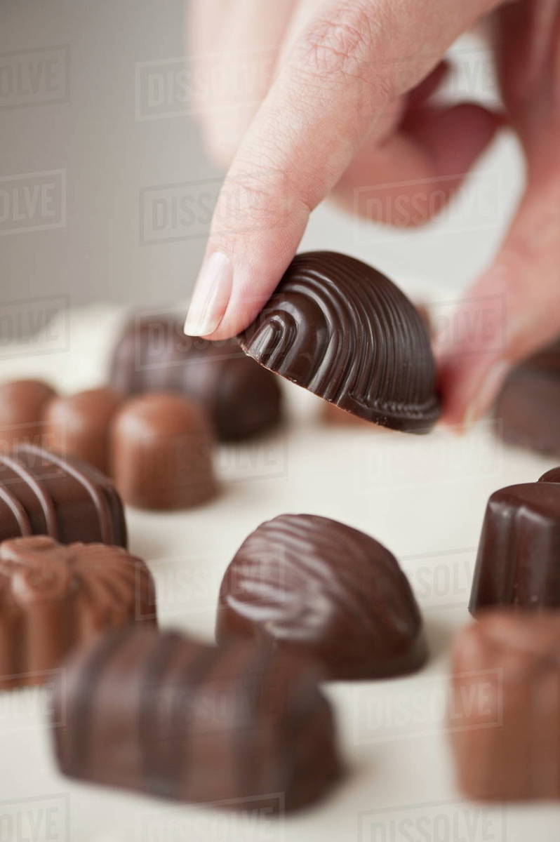 Woman's hand holding chocolate - Royalty-free Stock Photo | Dissolve