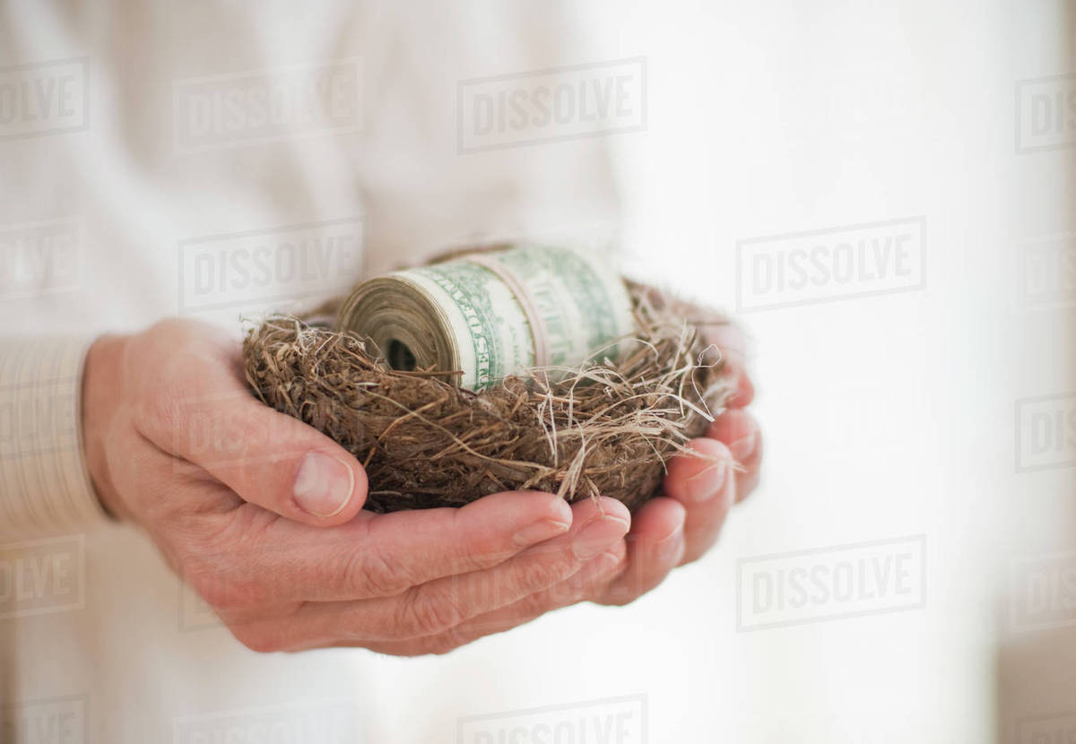 Hands holding a nest with money in it - Royalty-free Stock Photo | Dissolve