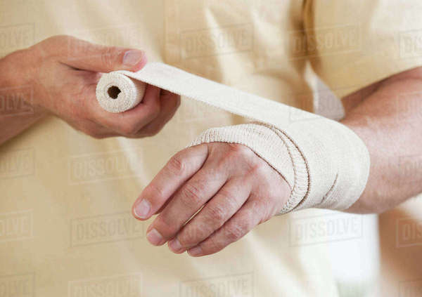 Man wrapping hand in tensor bandage - Royalty-free Stock Photo | Dissolve