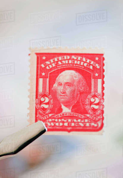 Tweezers holding stamp - Stock Photo - Dissolve
