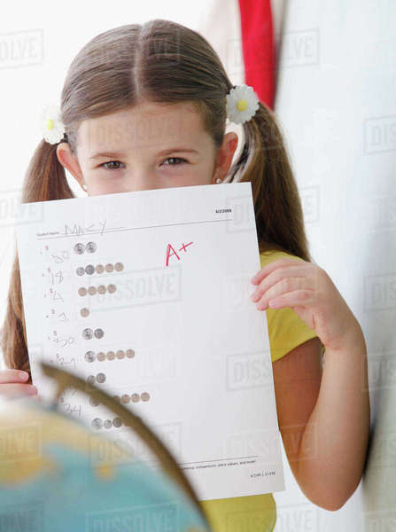 Child holding up grades - Royalty-free Stock Photo | Dissolve