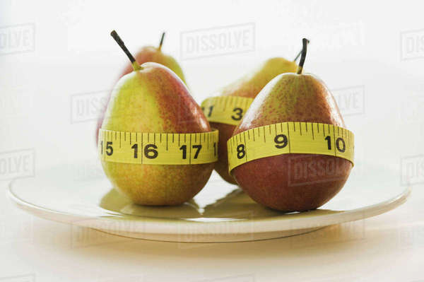 Pears wrapped in tape measures - Stock Photo - Dissolve