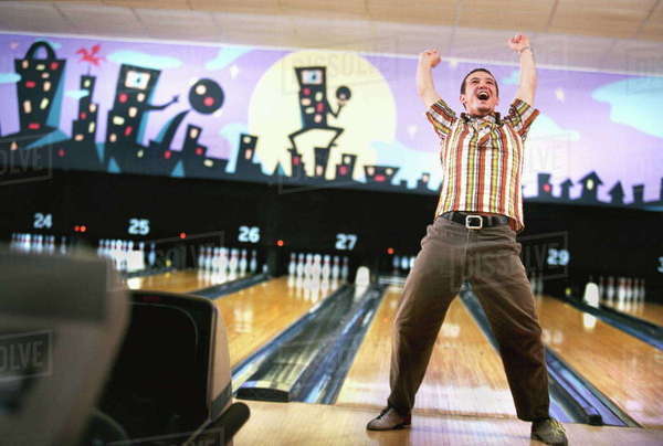 Man standing in front of bowling alley and cheering - Royalty-free ...