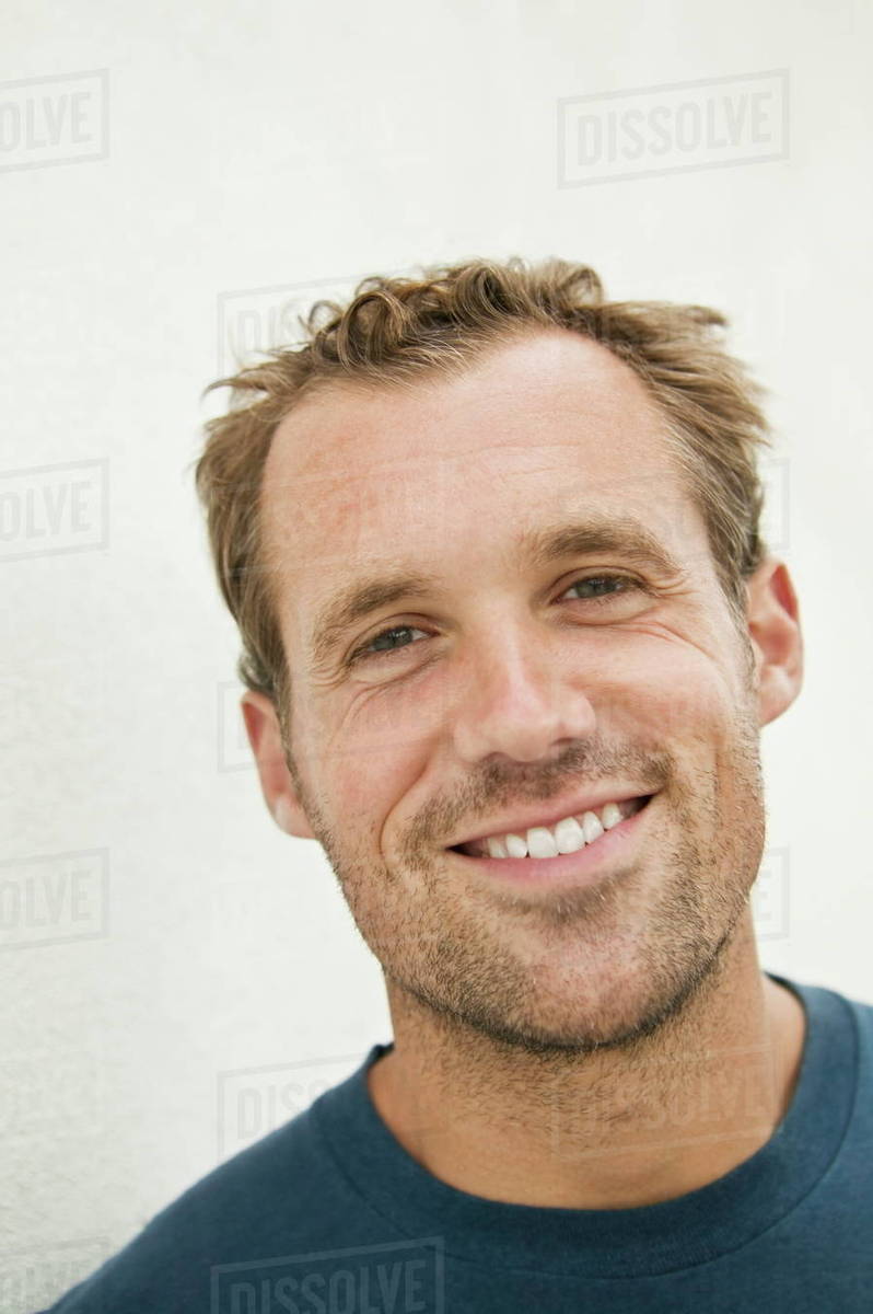 Mid adult man smiling, portrait - Royalty-free Stock Photo | Dissolve