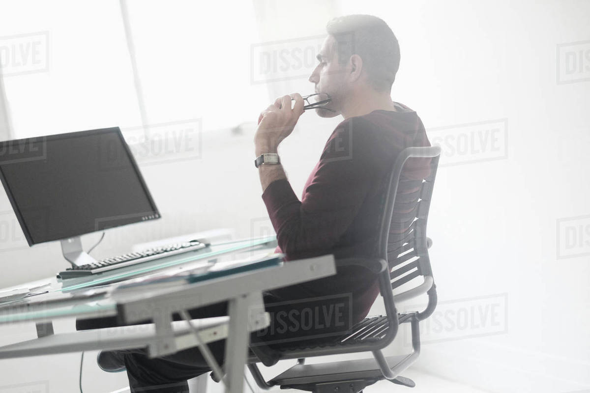 Man sitting at desk in office - Royalty-free Stock Photo | Dissolve