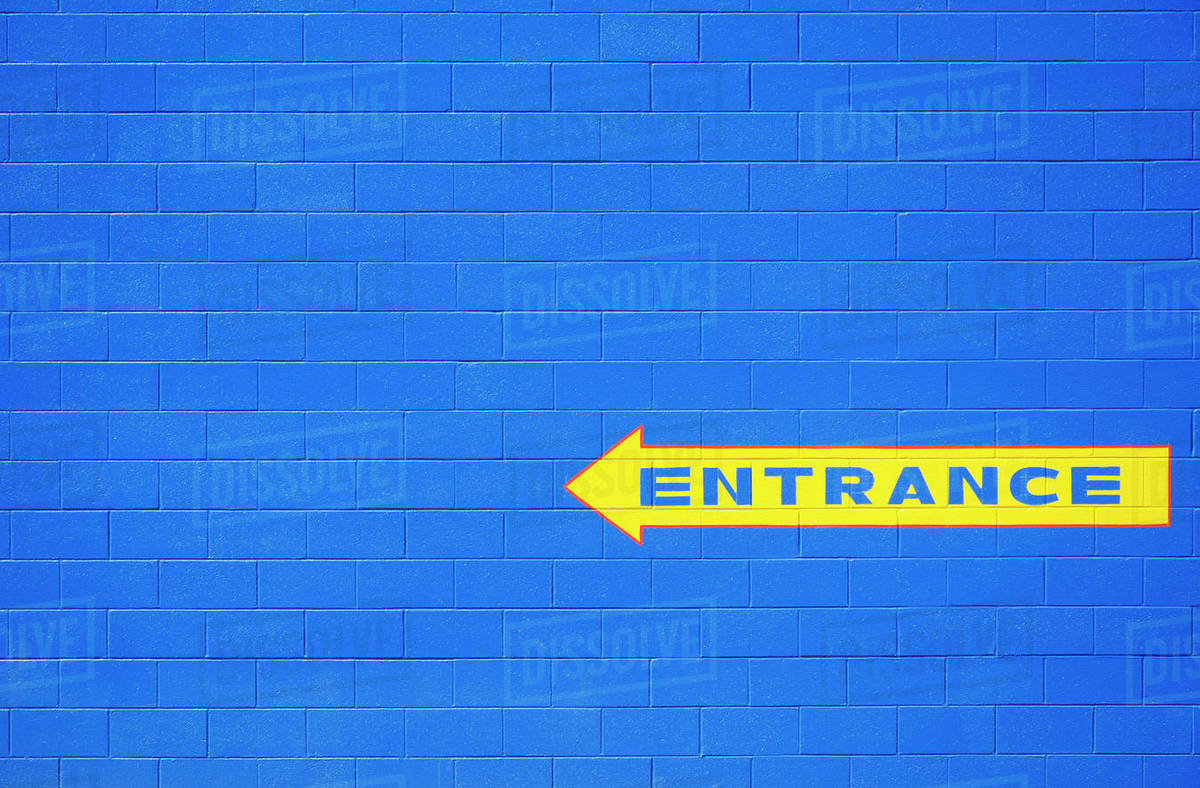 Blue wall with yellow entrance sign - Royalty-free Stock Photo | Dissolve