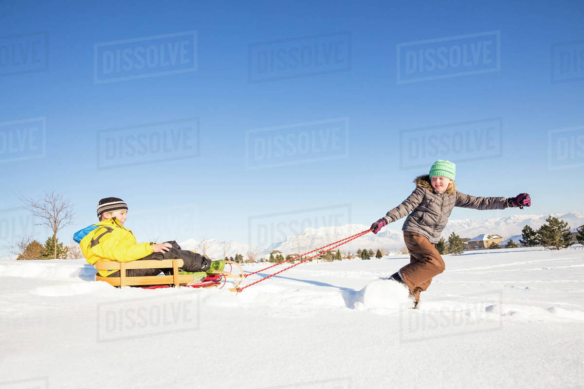 Children (8-9) playing with sled in snow - Royalty-free Stock Photo ...