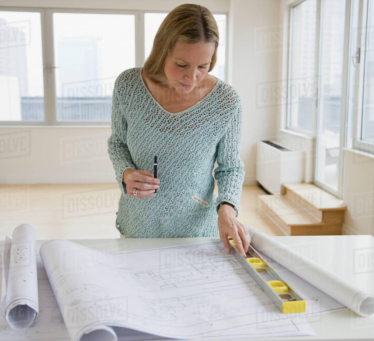 Woman looking at blueprints - Royalty-free Stock Photo | Dissolve