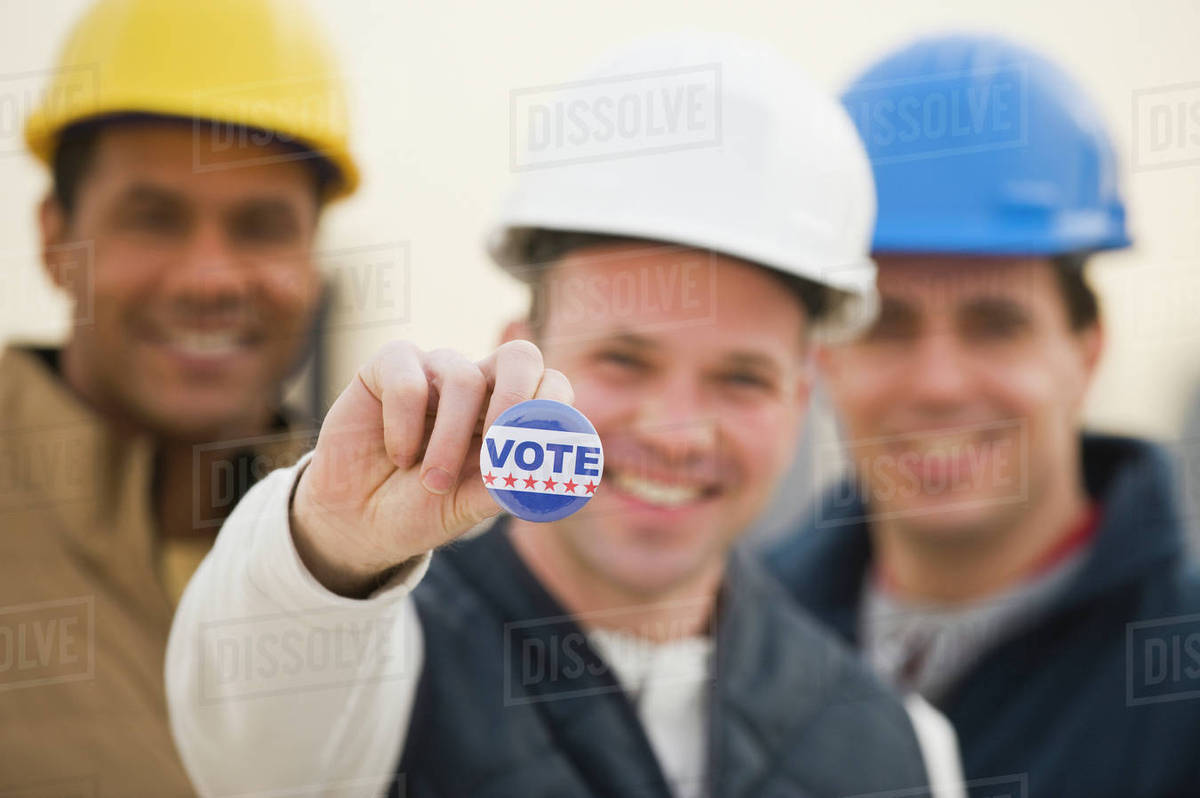 Multi-ethnic construction workers with Vote button - Stock Photo - Dissolve
