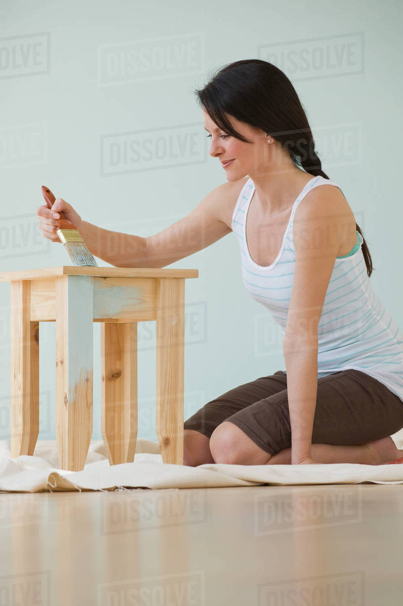 Woman painting wooden table - Royalty-free Stock Photo | Dissolve