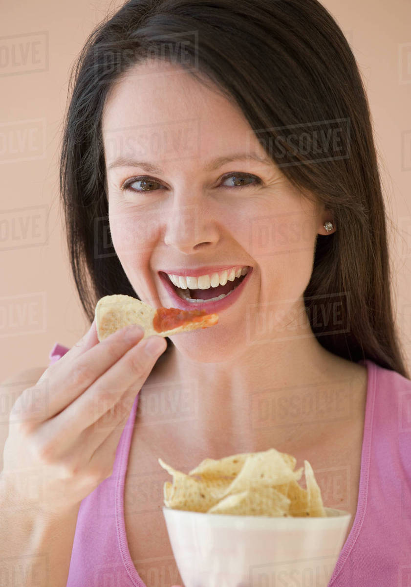 Woman eating chips and dip - Royalty-free Stock Photo | Dissolve