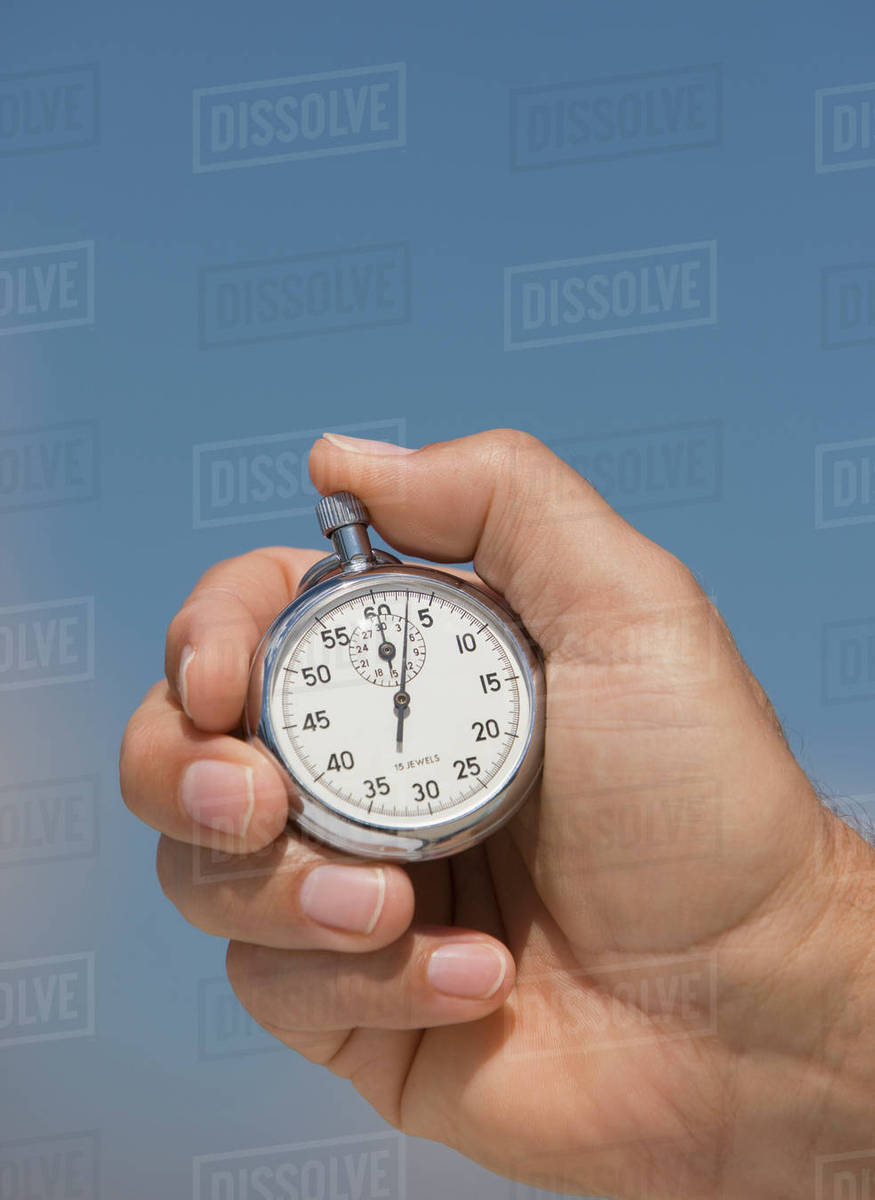 Close up of hand holding stopwatch - Stock Photo - Dissolve