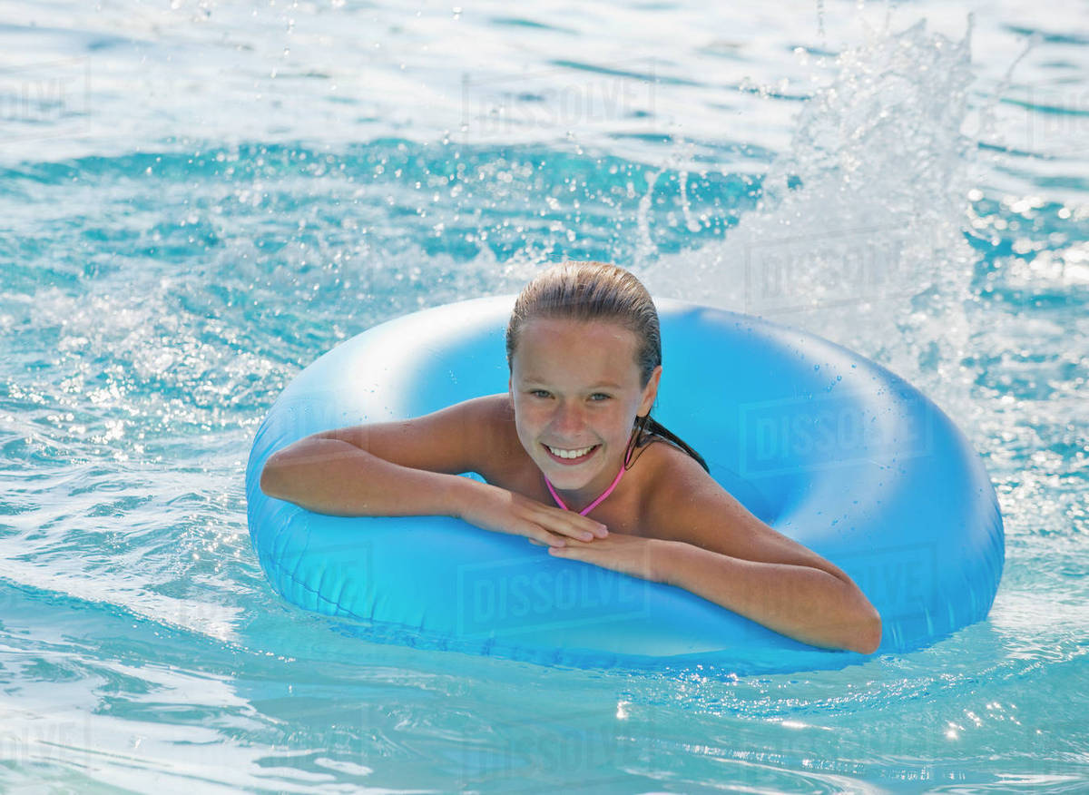 Girl playing with inflatable tube in swimming pool - Royalty-free Stock ...