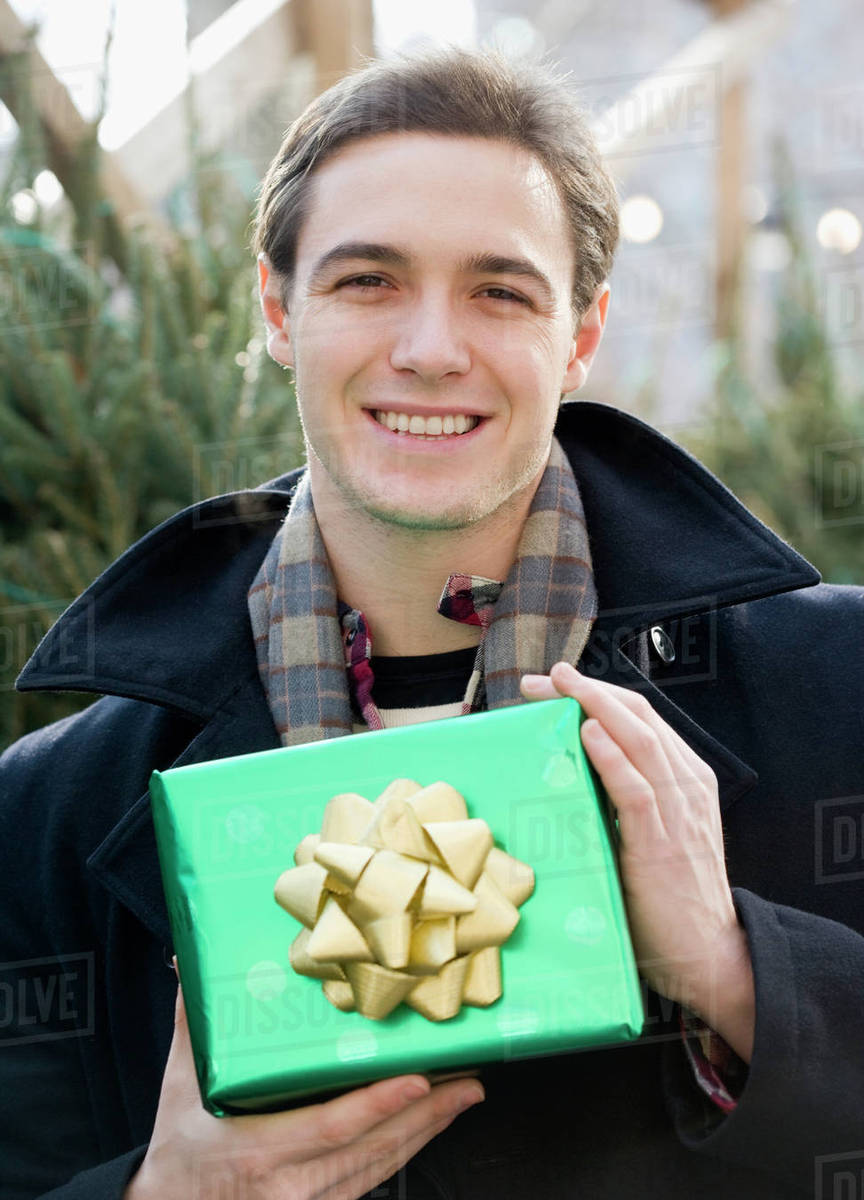 Man holding gift - Royalty-free Stock Photo | Dissolve