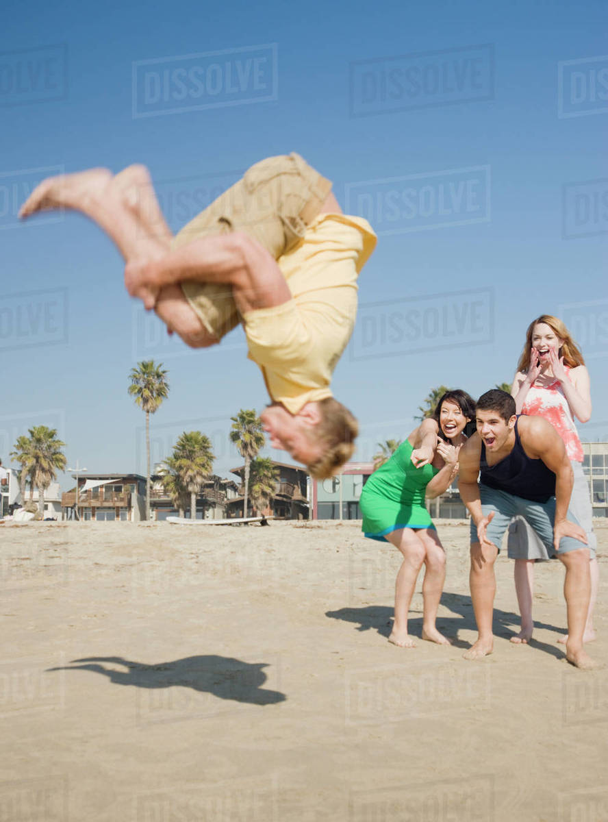 Man doing back flip on beach - Royalty-free Stock Photo | Dissolve