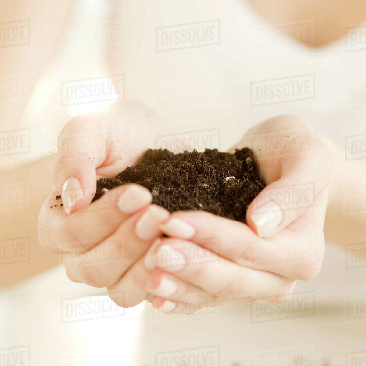 Woman holding handful of soil - Royalty-free Stock Photo | Dissolve